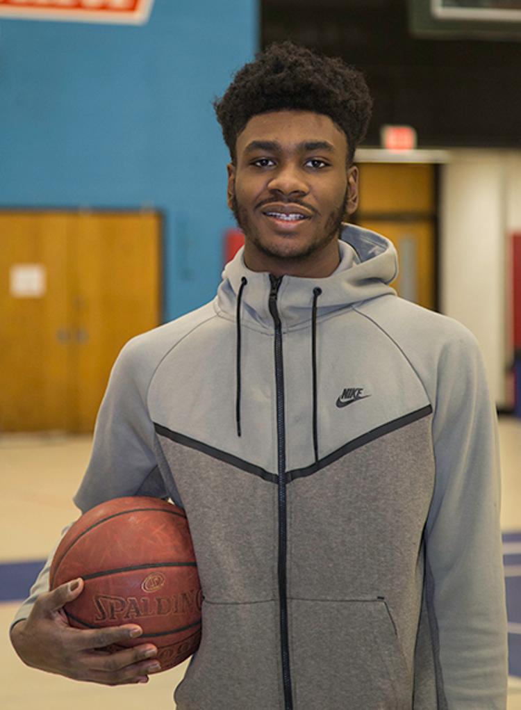 Quintin Dove in Tri-C gym, holding a basketball.